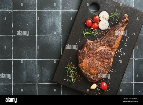 Tomahawk Steak Sliced Grilled Tomahawk Beef Steak With Baked Cherry Tomatoes Herbs And Salt On