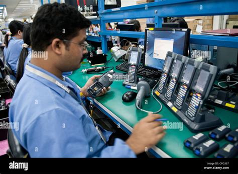 Workers Test Hand Held Inventory Computer Devices On The Assembly Line