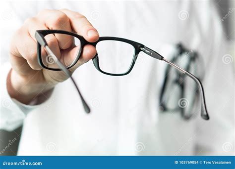 Optician Giving New Glasses To Customer For Testing And Trying Stock
