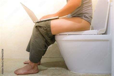 Using A Laptop Computer On A Toilet The Asian Man Sitting In The Toilet And Working At The