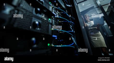 It Engineer Standing Before Working Server Rack Doing Routine Maintenance Check And Diagnostics