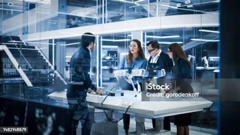 로봇 공학 엔지니어 프로젝트 관리자 및 기계 운영자는 로봇 개 프로젝트에서 협력하고 과학 기술 연구소에서 노트북 컴퓨터와 함께