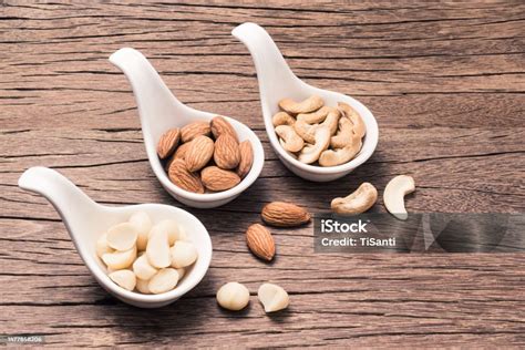 유기농 캐슈넛 아몬드 너트 마카다미아 너트를 숟가락 모양의 컵에 담아 오래된 나무 공간에 0명에 대한 스톡 사진 및 기타 이미지 Istock