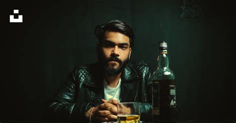 검은 가죽 재킷을 입고 투명한 음료수 유리를 들고 있는 남자 사진 Unsplash의 무료 검정 이미지