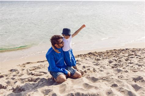 Premium Photo Dad And Son Play On Beach In Summer In Blue Clothes