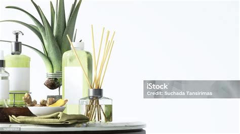 빈 라벨 열대 식물 향기 스틱 흰색 배경의 대리석 사이드 테이블에 수건이 있는 유리병 녹색 기름의 모형 향기로운에 대한 스톡