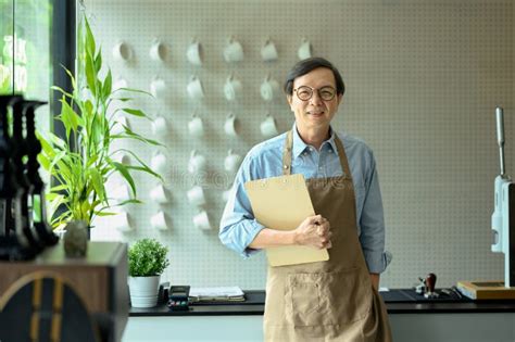 Middle Aged Man Coffee Shop Owner Wearing Apron Standing In Front Of