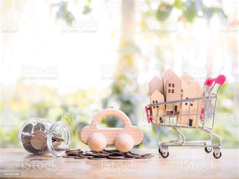 쇼핑 카트에있는 미니어처 하우스와 동전 더미에 나무 장난감 자동차 미래에 집과 차를 사기 위해 돈을 절약하십시오 개념에 대한 스톡 사진 및 기타 이미지 Istock