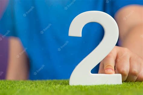 Premium Photo White Number 2 In Hand The Hand Holding The Number 2
