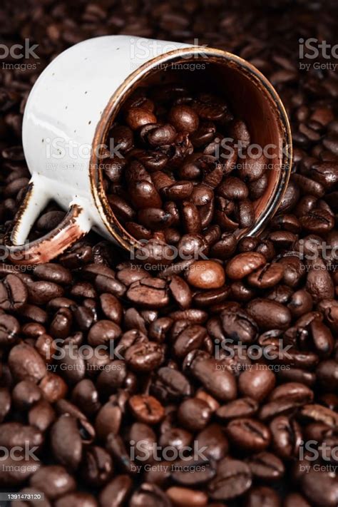 볶은 커피 원두와 커피 컵을 마실 준비가 된 커피 원두의 질감 선택적 초점 로스팅 및 커피 준비 수직 프레임 0명에 대한 스톡