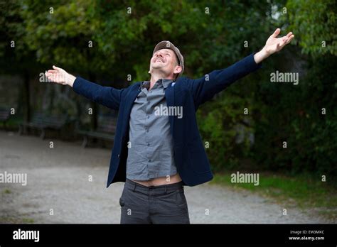 Man Standing In Park And Spreading His Arms Out Of Happiness Stock