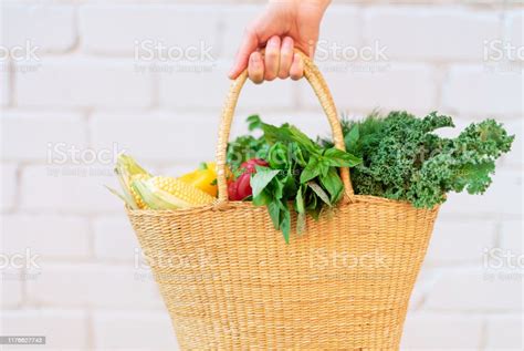 건강한 유기농 야채 벽돌 배경 복사 공간으로 밀짚 바구니를 들고있는 소녀 가을 수확 제로 폐기물 플라스틱 무료 개념 지속 가능한 라이프 스타일 추수 감사절 구매에 대한 스톡