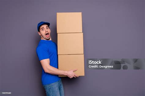 클로즈업 사진 멋진 직업 전문가 그 그 그의 배달 소년 개최 강한 팔 큰 무거운 소포 상자 변경 장소 플랫 이동 착용 블루