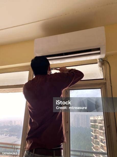 Image Of Indian Handyman Fitting A Glass Pane Into A Window Frame Stock