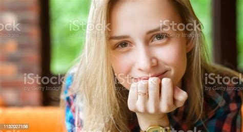 격자 무늬 셔츠에 아름 다운 눈을 가진 소녀는 큰 유리창의 배경에 대 한 여름 카페에 앉아 있다 20 29세에 대한 스톡 사진