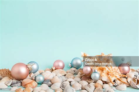 파스텔 블루 배경에 크리스마스 공과 조개껍데기의 프레임 밝고 다채로운 미니멀 아트 구성 크리스마스와 새해의 개념 공간을