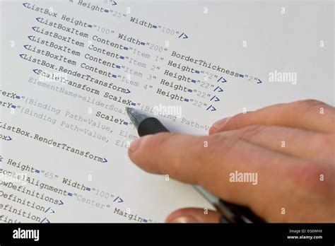a programmer man pointing with his pen at software computer code