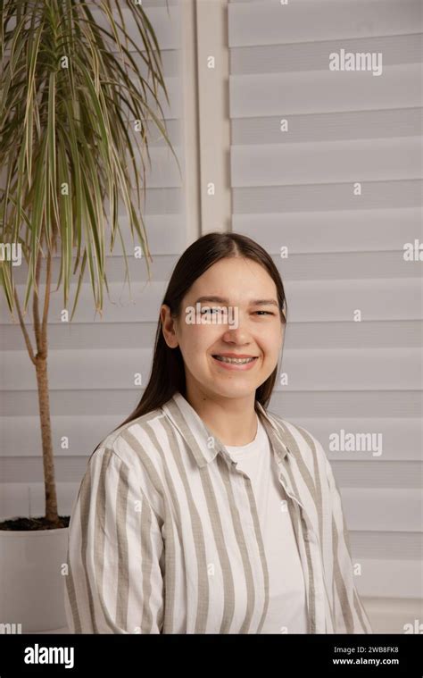 Smiling Woman With Braces Looking At Camera In Room With White Closed