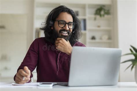 Remote Work Smiling Indian Male Freelancer Working With Laptop At Home
