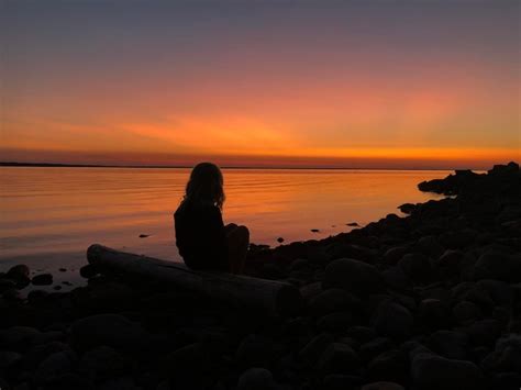 Premium Photo Girl Sitting On Rocks At Beach During Sunset