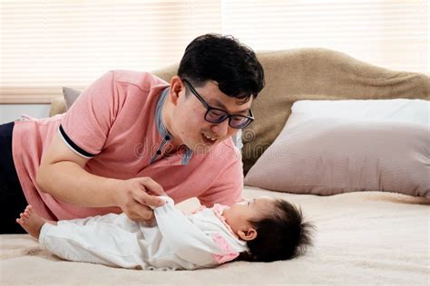 Handsome Asian Father Wearing Pink Shirt Lying And Teasing With His