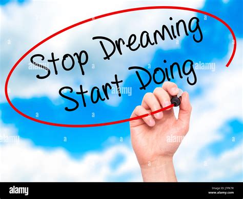 Man Hand Writing Stop Dreaming Start Doing With Black Marker On Visual