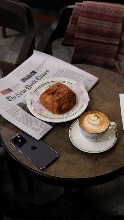 거품 예술 기술 냅킨 뉴스 뉴욕 타임즈 도자기 컵 독서하는 디지털 해독 따뜻한 음색 라떼 라떼 아트 랩 크루아상 레저 모닝 커피 목조 테이블