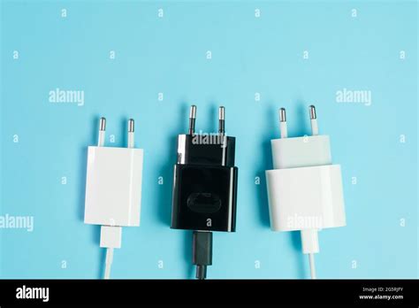 Power Plugs With USB A And USB Type C Connectors From Smartphone Charger On The Blue Background