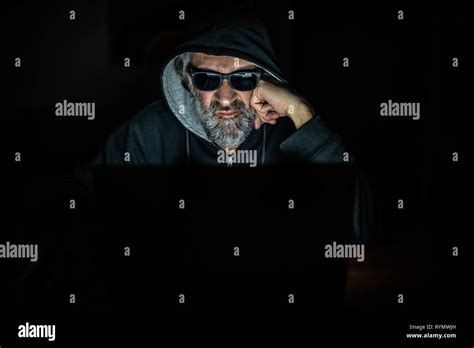 Male Hacker With Beard And Sunglasses Working On His Laptop Annoyed Male Hacker With Beard And Sunglasses Working On His Laptop Annoyed