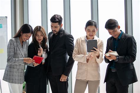 직장에서 이야기하는 비즈니스 팀 남성과 여성 동료는 손에 데이터 보고서와 아이디어를 공유하고 행복한 동료는 사무실에서 함께 일합니다 20 29세에 대한 스톡 사진 및 기타