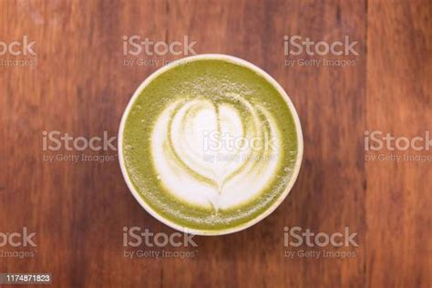 커피숍의 목재 테이블에 그린 말차 라떼 아트 폼을 곁들인 커피 컵 커피는 가장 인기있는 음료 중 하나입니다 에너지 레벨을 개선 하 고 지방 을 태워 건강한 생활방식에 대한