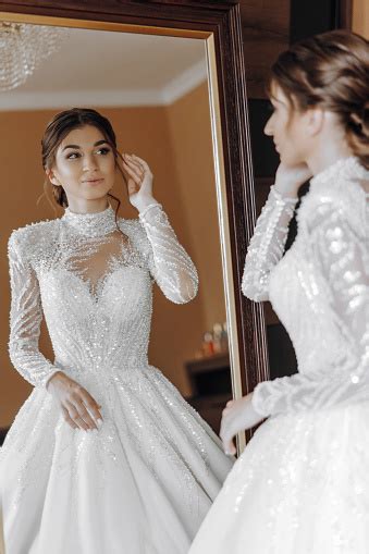 한 여자가 긴 흰 드레스를 입고 거울에 비친 자신의 모습을 보고 있다 20 24세에 대한 스톡 사진 및 기타 이미지 20