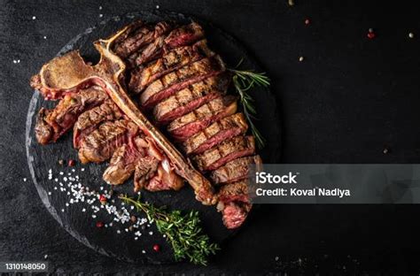 얇게 썰고 구운 T뼈 또는 포터하우스 쇠고기 고기 스테이크는 검은 색 배경의 스테이크하우스 메뉴를 제공합니다 텍스트 상단 보기 메뉴 레시피 장소 Steakhouse에 대한