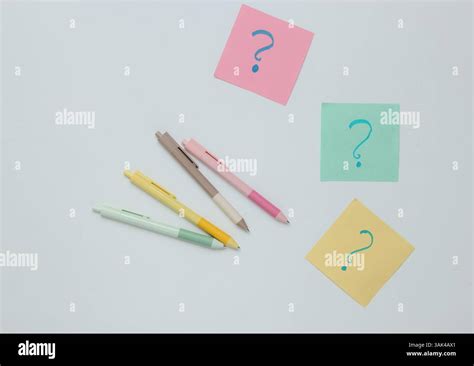 Pens And Memo Piece Of Paper With Question Marks On White Background