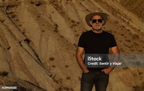 Pria Dewasa Dengan Topi Koboi Dan Kacamata Hitam Di Padang Pasir