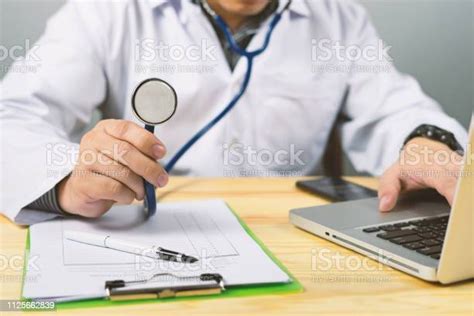 클립보드와 손에 청진 기 및 노트북 데스크 처방전을 작성 하는 병원에서 근무 하는 의사 의료 및 의료 개념 배경 빈티지 색상 선택적 초점 테스트 결과 간호사에 대한 스톡