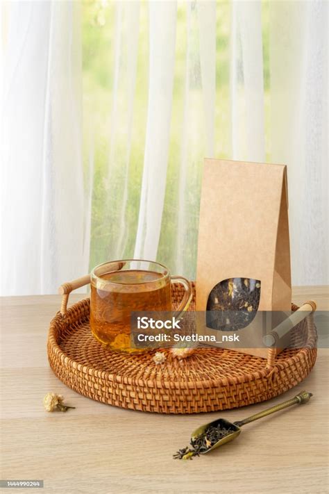 유기농 차 브랜딩 및 포장 모형 테이블에 유리 주전자에 재스민 녹차 뜨거운 차가 유리 컵에 있습니다 테이블에 녹차를 곁들인 주전자와 차 한잔 공간을 복사합니다 거친에 대한