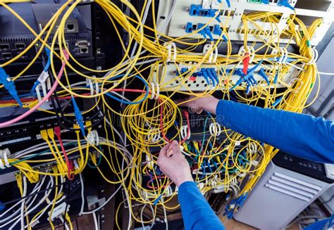 Network Engineer Working In Server Room Connecting Network Cables To Switches Stock Image