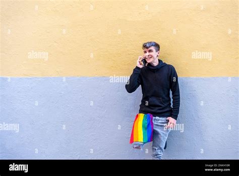 Non Binary Person With An Lgbt Rainbow Flag Talking On The Phone Outdoors Stock Photo Alamy