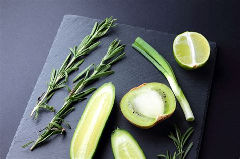 녹색 과일 그리고 야채 어두운 슬레이트 보드에 자연 그린 제품의 개념입니다 아보카도 키 위 라임 및 어두운 배경에 애플 로즈마리 딜과 돌 보드에 향신료 건강한 생활방식에