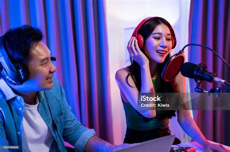 아시아 오디오 Dj 남자와 여자가 마이크에 마이크를 대고 방송에 나선다 젊은 아름다운 여성과 남성 블로거 영향력있는 사람이 헤드폰을 착용하고 스튜디오에서 라디오를위한 아침