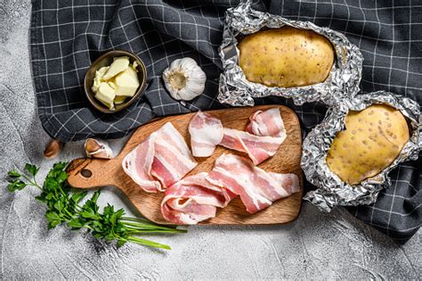 베이컨 버터 파슬리 치즈로 구운 감자를 요리하는 재료 회색 배경 위쪽 보기 0명에 대한 스톡 사진 및 기타 이미지 0명