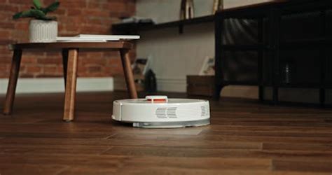A Woman Turning On The Robotic Vacuum To Clean The Floor · Free Stock Video