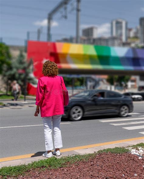 Rear View Of Pedestrian Waiting In The Wrong Place To Cross Not At A
