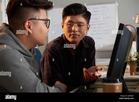 Handsome Young Programmers Wearing Eyeglasses Having Productive Discussion Of Joint Project
