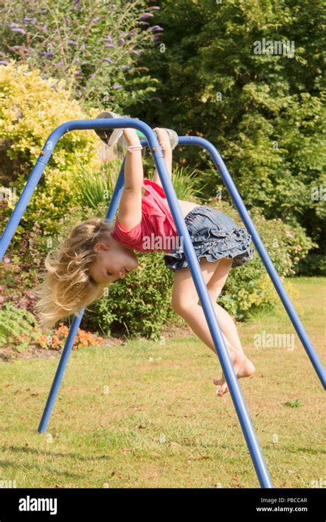 Three Year Old Girl Doing Gymnastics Acrobatics On Apparatus In Back