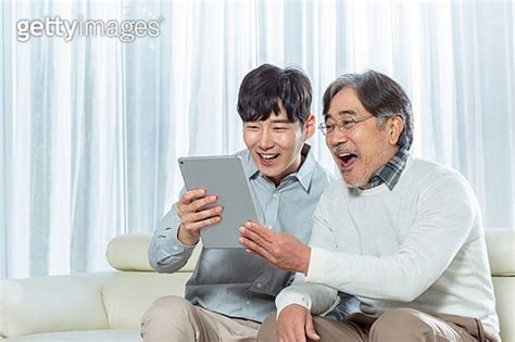 남성 아빠 부모 아들 거실 스마트기기 정보장비 가르치는 움직이는활동 미소 이미지 Jv11334658