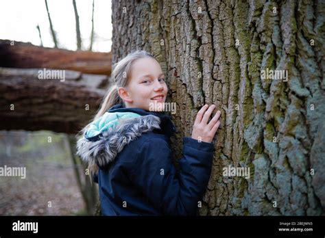 A Girl Leans At The Trunk Of A Huge Tree Stock Photo Alamy