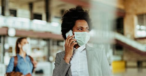 공항에서 휴대 전화로 통신하는 동안 보호 마스크를 착용 한 아프리카 계 미국인 사업가 사진 Unsplash의 세르비아 이미지