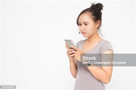 흰색 배경과 복사 공간에 스마트 폰을 들고 회색 캐주얼 셔츠를 입고 아름다운 아시아 여성 귀여운 아시아 여자는 화가 소셜 미디어 개념에 대한 무언가에 대해 채팅 25 29